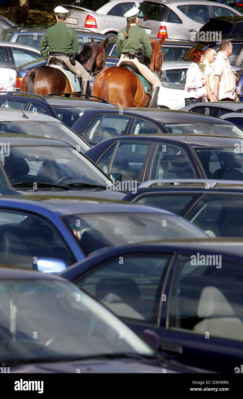(dpa) - Mounted police officers ride on their horses between filled ...