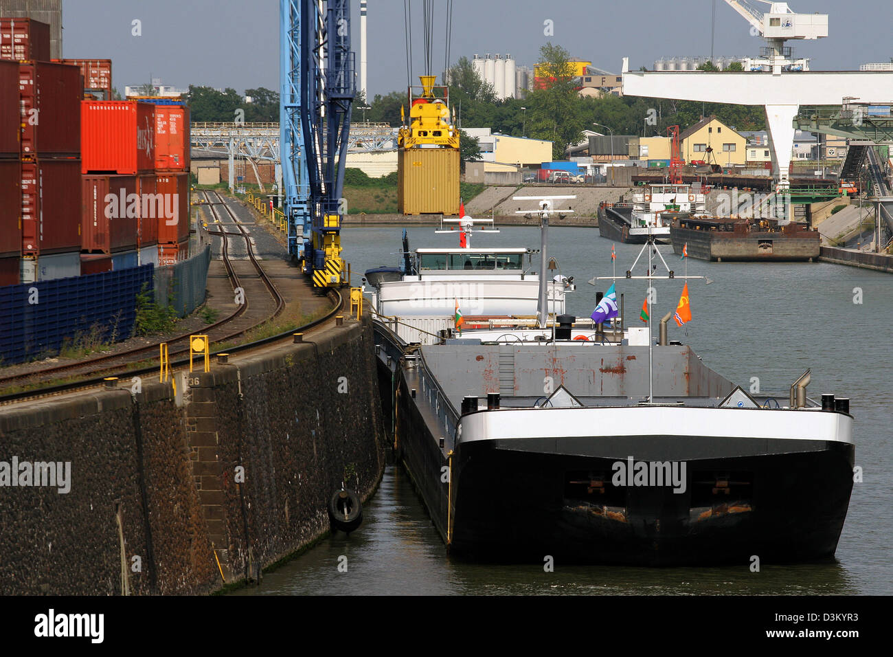 (dpa) - Cranes load containers onto a river barge at the container ...