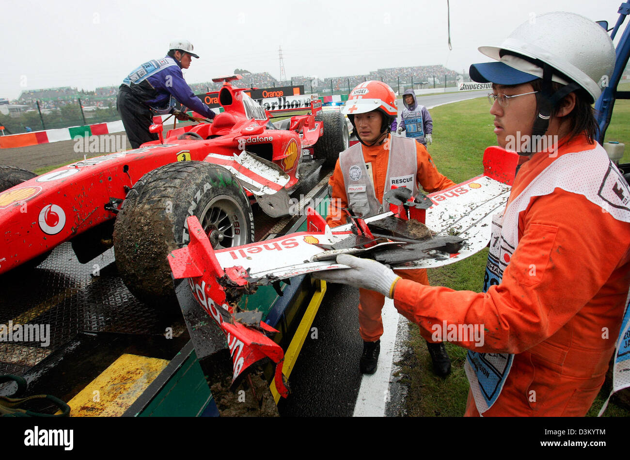(dpa) - Marshalls take away debris of the Ferrari of German Formula One ...