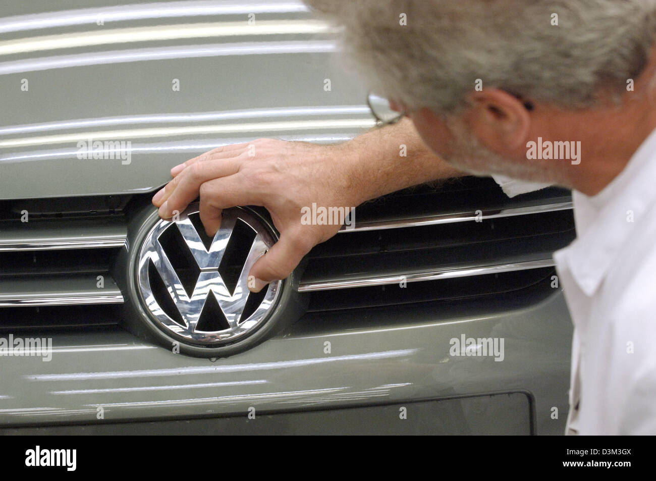 (dpa) - A Volkswagen car mechanic inspects a Golf model of the new ...