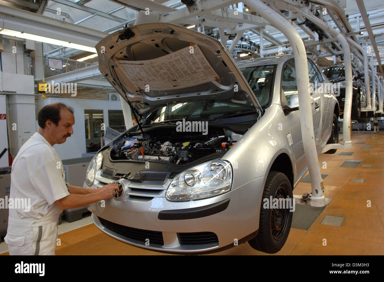 (dpa) - AVolkswagen car mechanic inspects a Golf model of the new fifth ...
