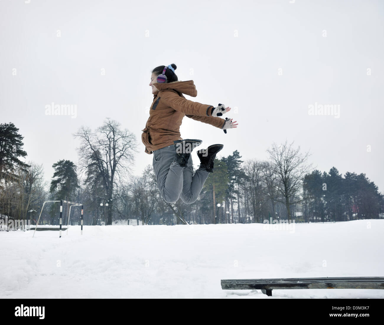 Woman jumping in snow Stock Photo - Alamy