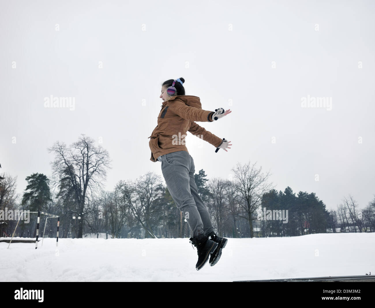 Woman jumping in snow Stock Photo - Alamy