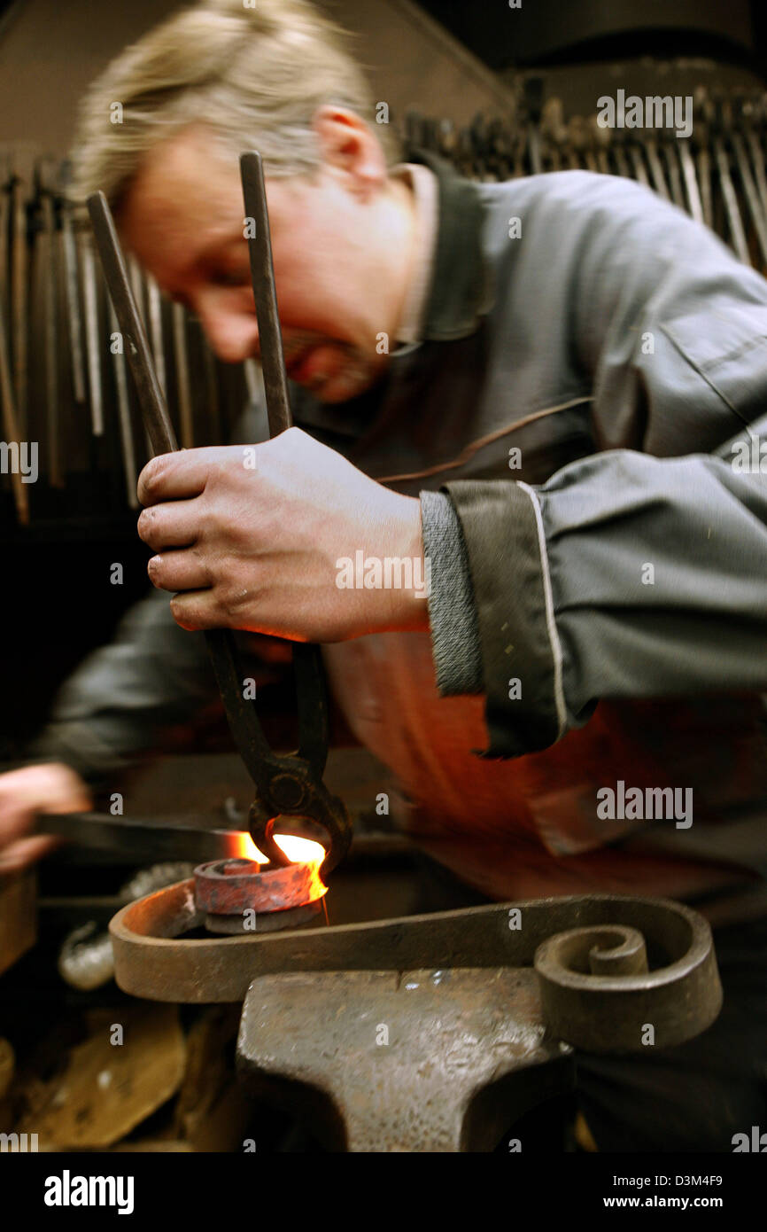 (dpa) - Blacksmith Michael Kastner bends a glowing piece of iron into a ...