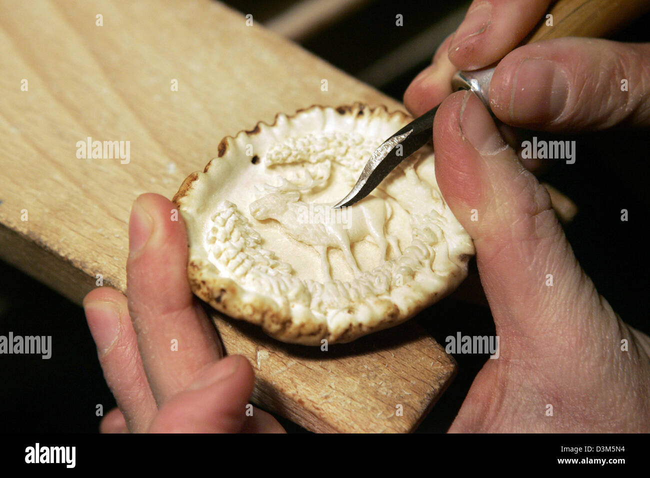(dpa) - A carver creates a relief of a piece of mammoth ivory at the ...