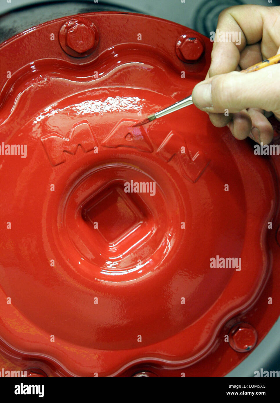 (dpa) - A production staff member paints with the logo of German lorry ...