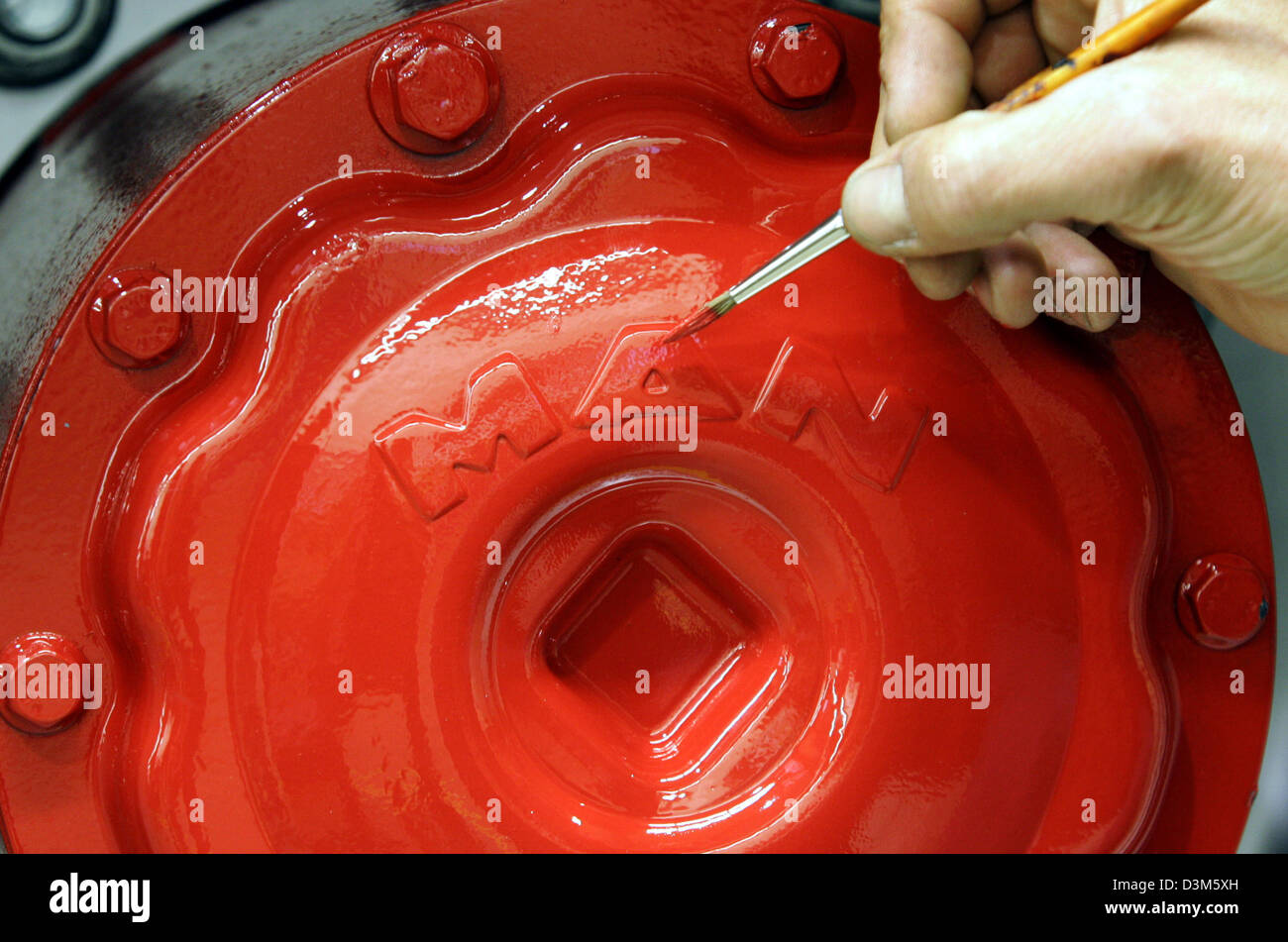 (dpa) - A production staff member paints with the logo of German lorry ...