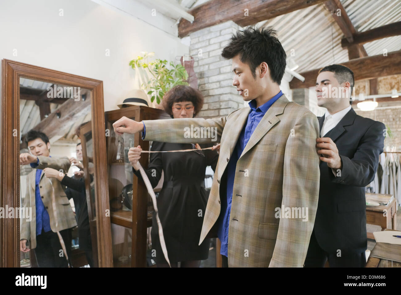 Local Chinese bespoke clothes shop business owner and assistant giving ...