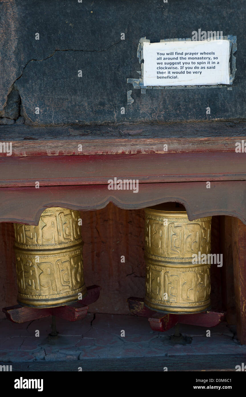 Prayer wheels and a sign recommending walking clockwise at the Thiksey ...