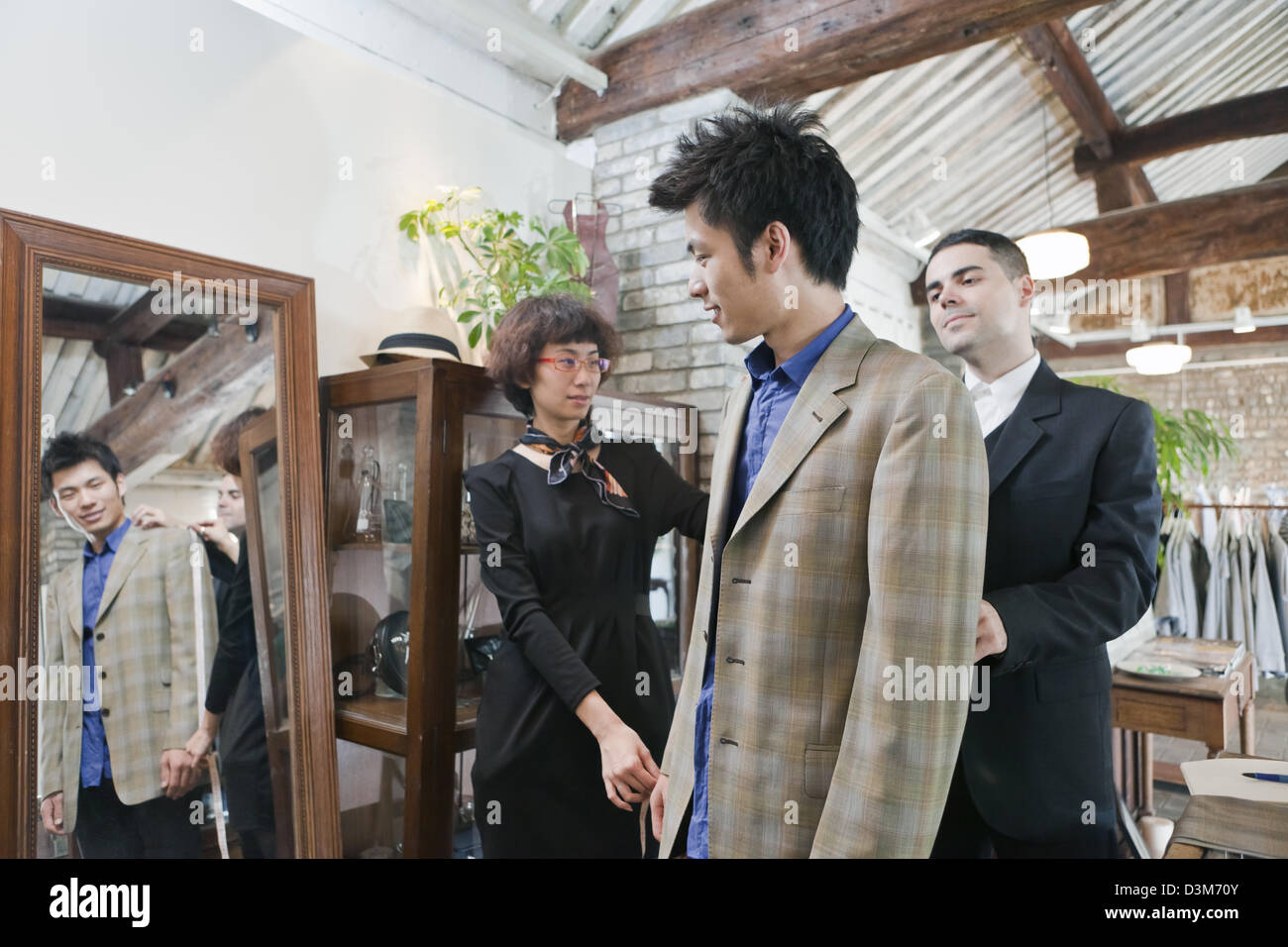 Local Chinese bespoke clothes shop business owner and assistant giving ...