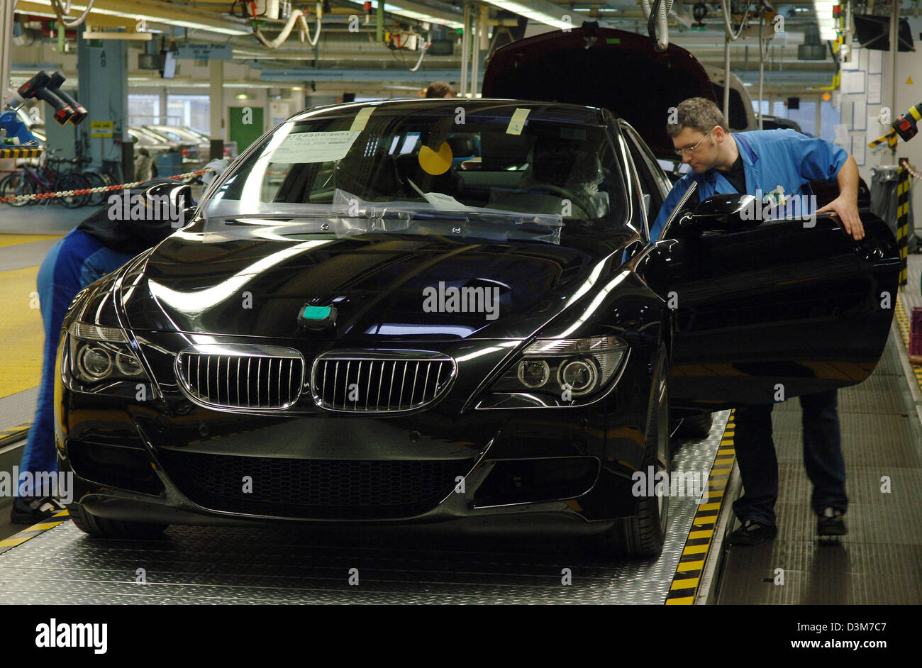 (dpa) - The picture shows two BMW employees during the final inspection ...