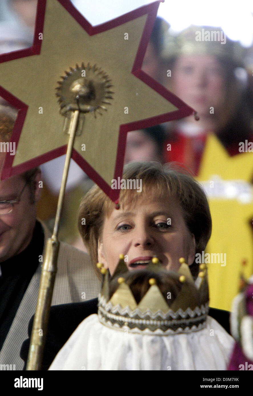 (dpa) - German Chancellor Angela Merkel (C, covered) smiles as she ...