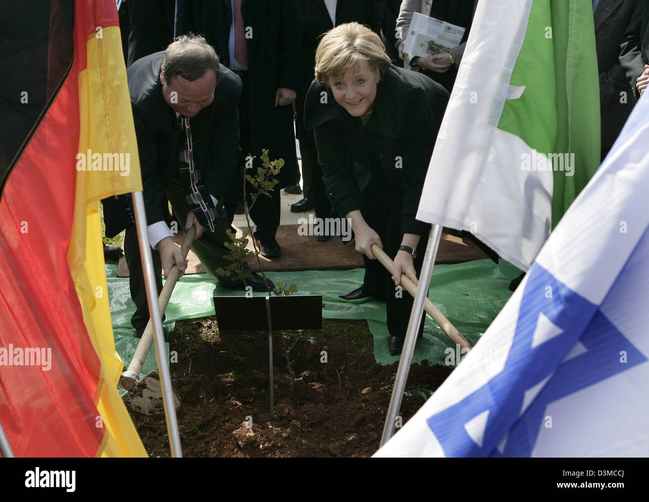 German Chancellor Angela Merkel plants an olive tree together with the ...