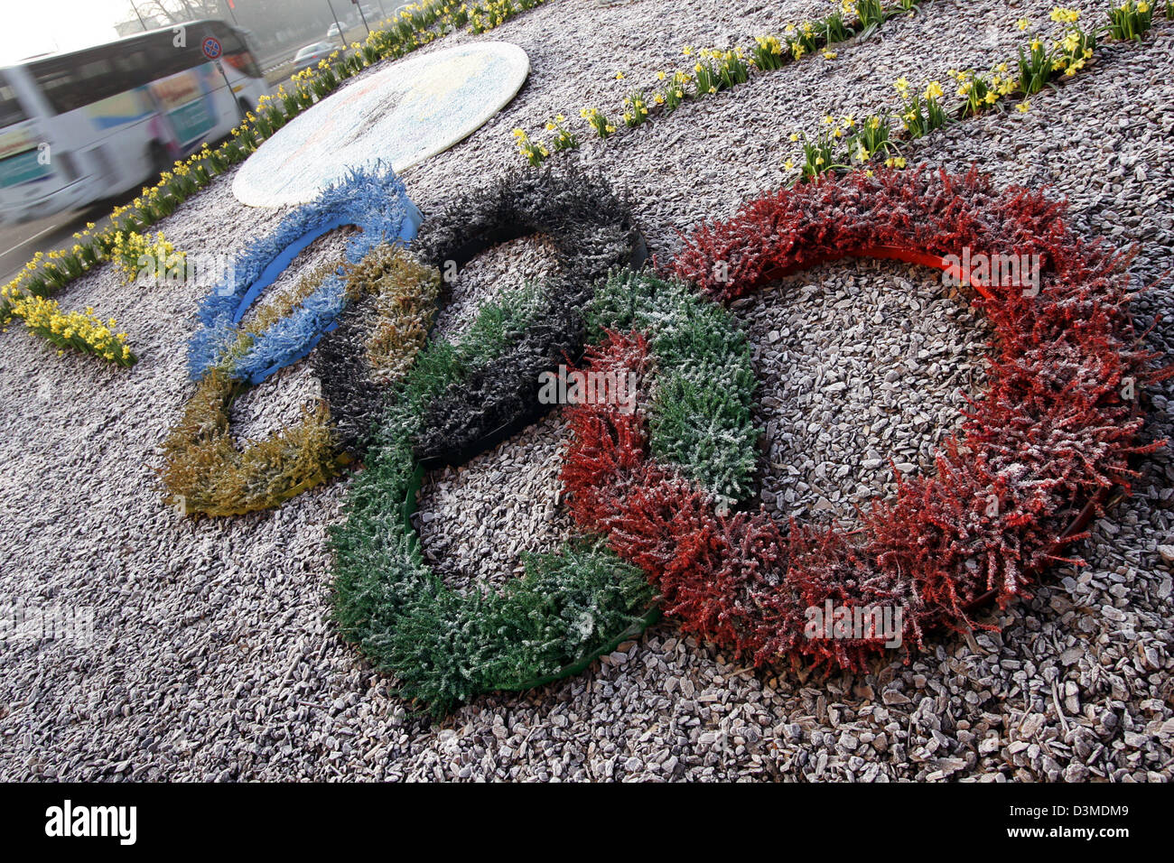 The picture shows a travel bus passing the Olympic emblem made with ...