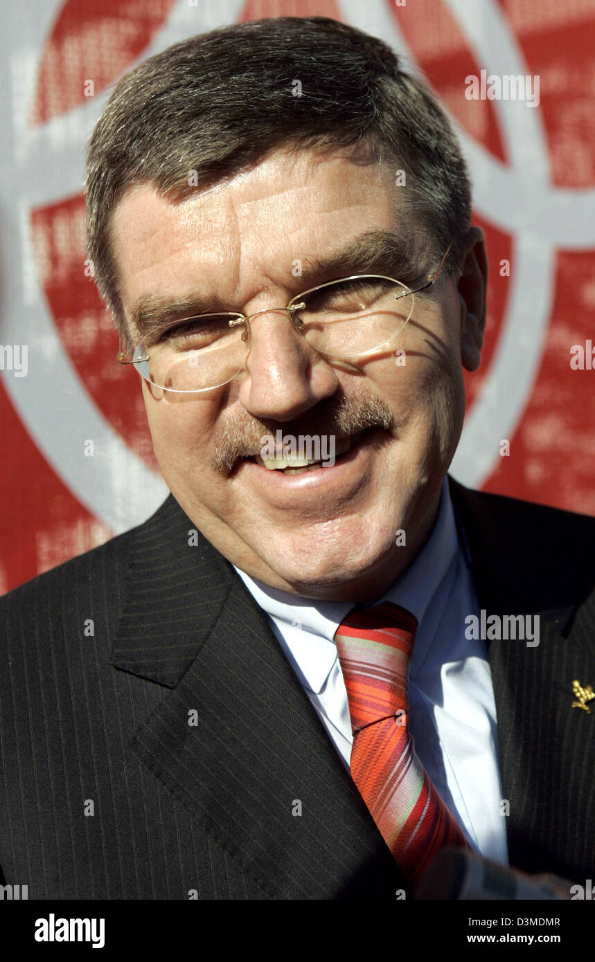 German Thomas Bach smiles in front of the Olympic emblem in Turin ...