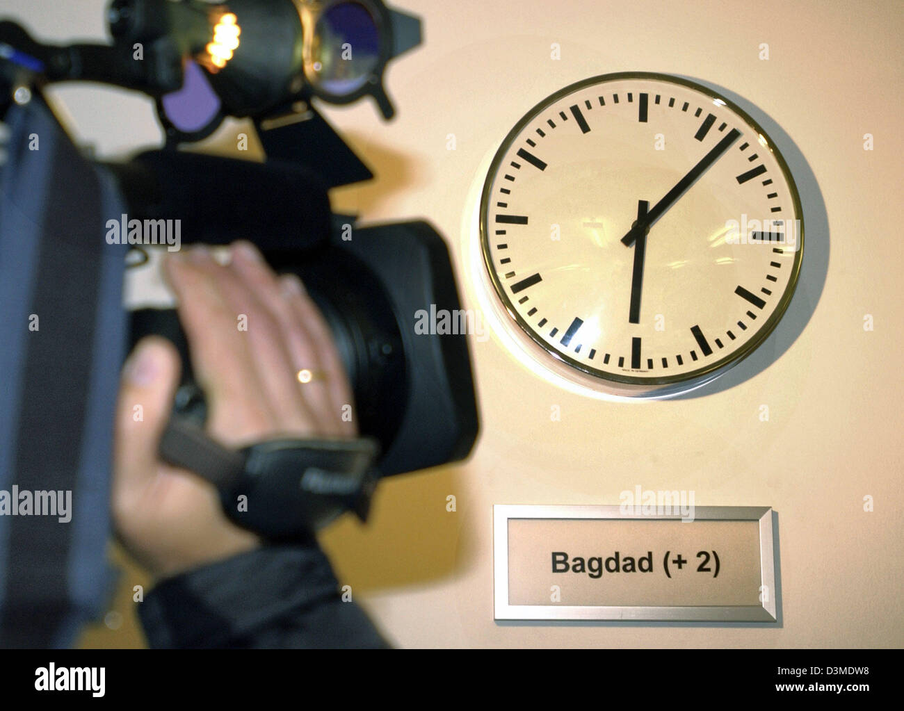 A cameraman shoots a clock showing Baghdad local time prior to the ...