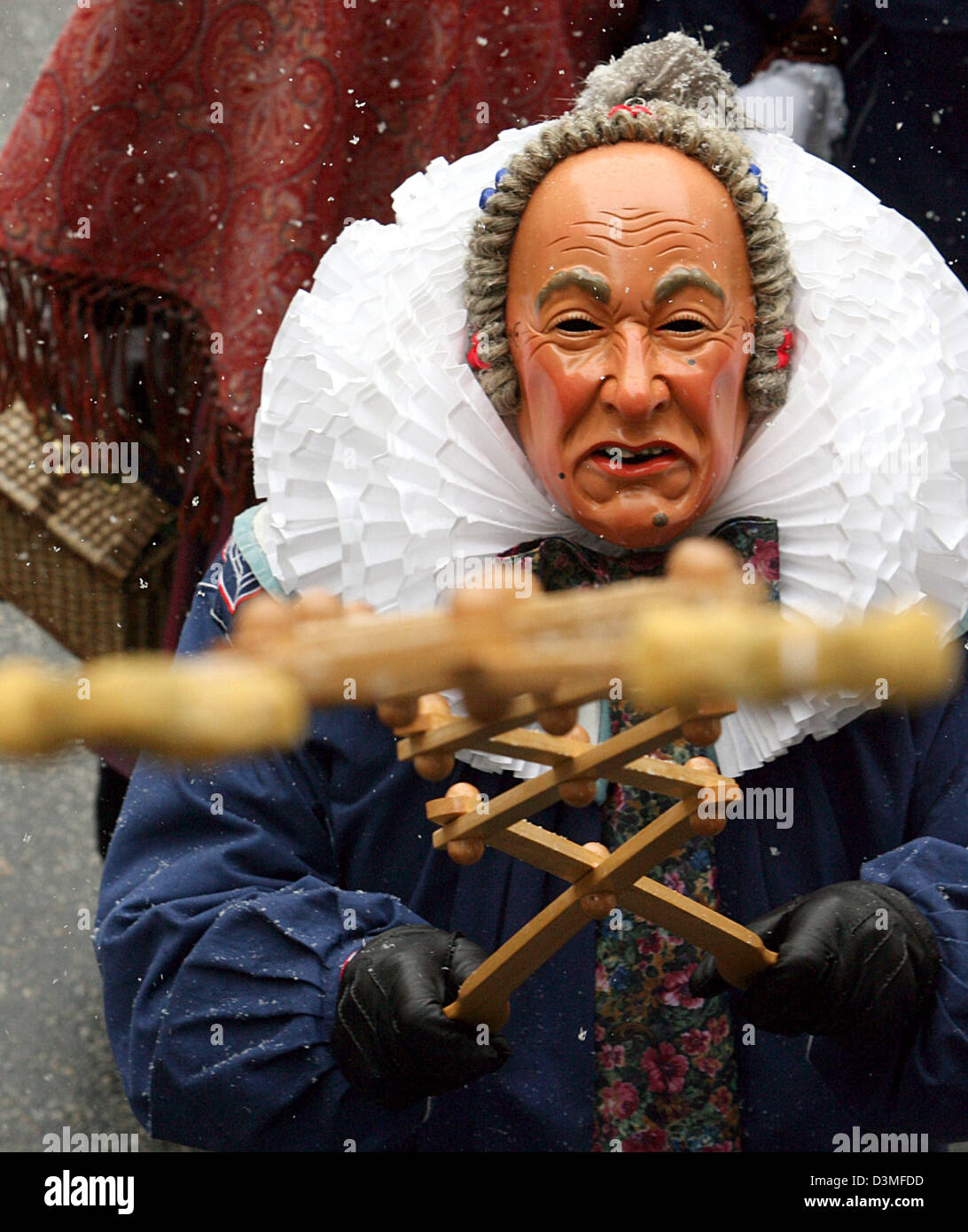A traditional carnival fool tries get hold of the camera of the ...