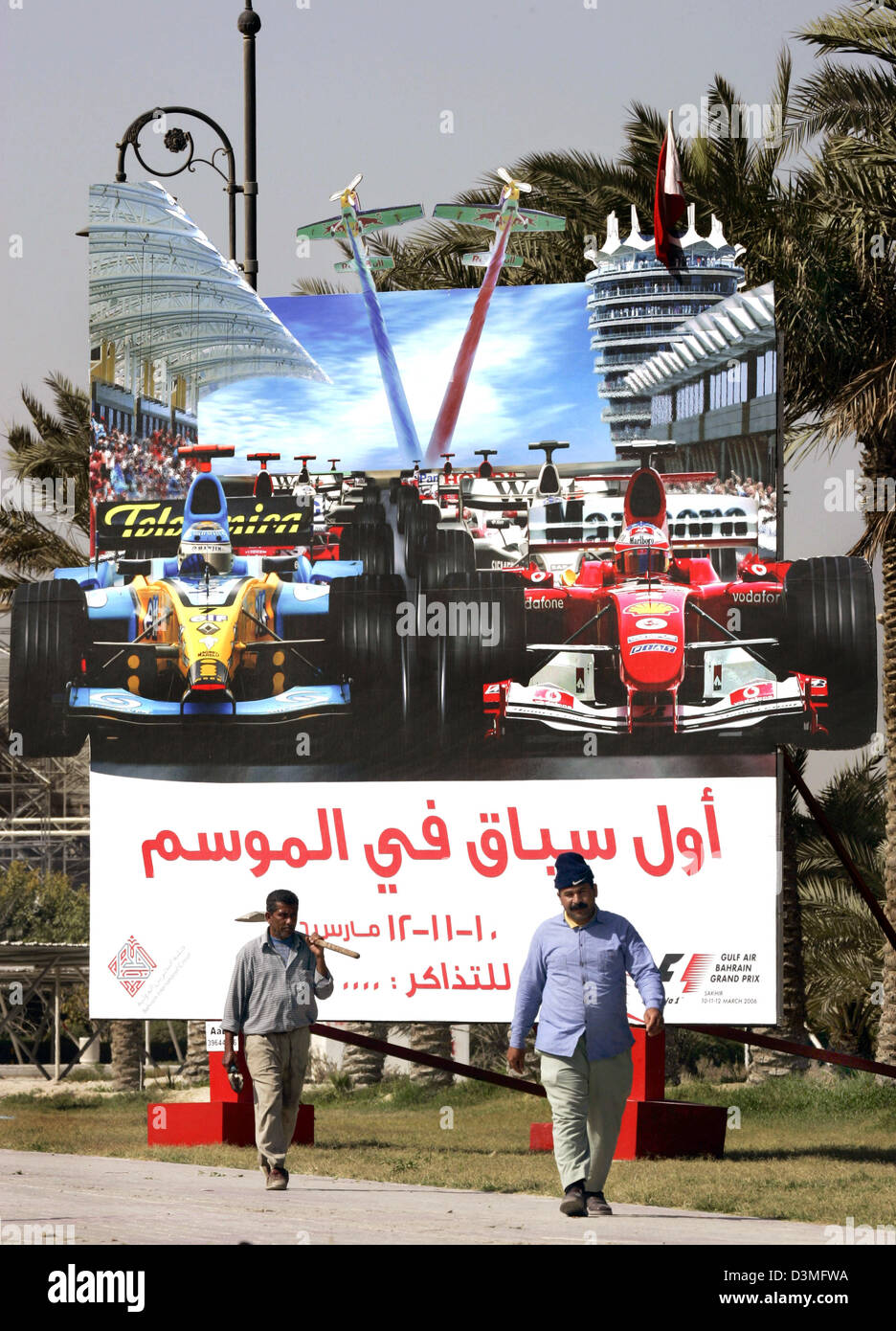 Two workers walk in front of a giant advertising poster for the ...