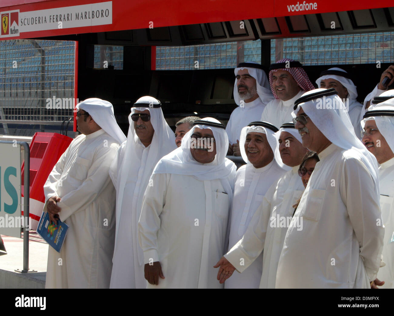 A group of sheiks poses in front of the Ferrari's control desk at the ...