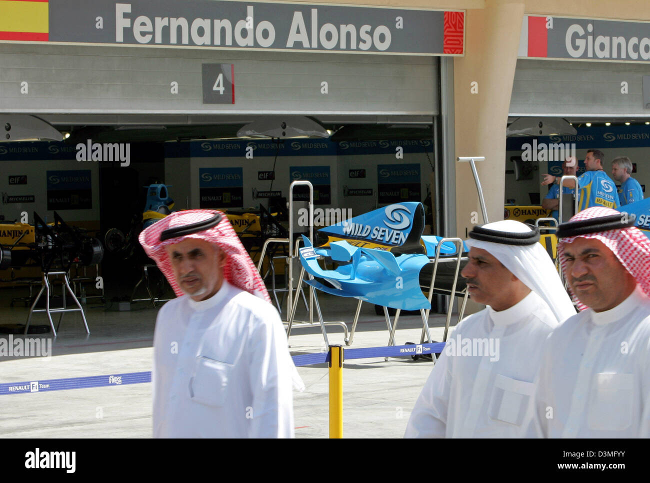 A group of sheiks walks past the Renault garage in the pit lane at the ...