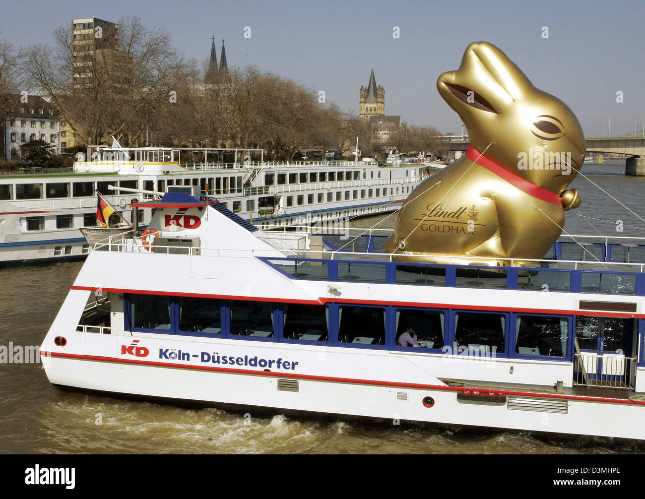 A huge golden Lindt Bunny travels on the upper deck of a tourist boat ...