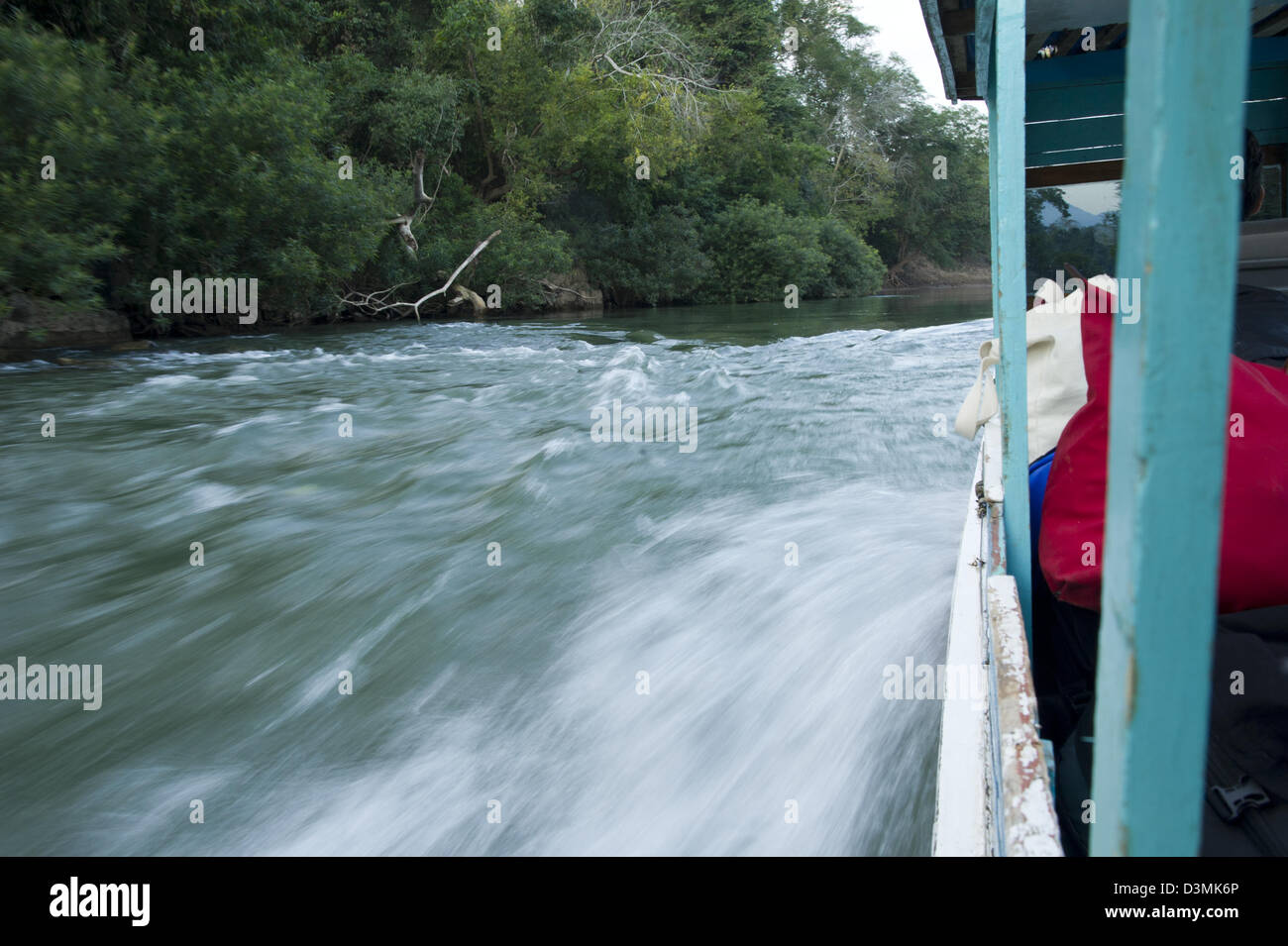 Water rushes by as a boat speeds through the rapids on the Nam Ou Stock ...