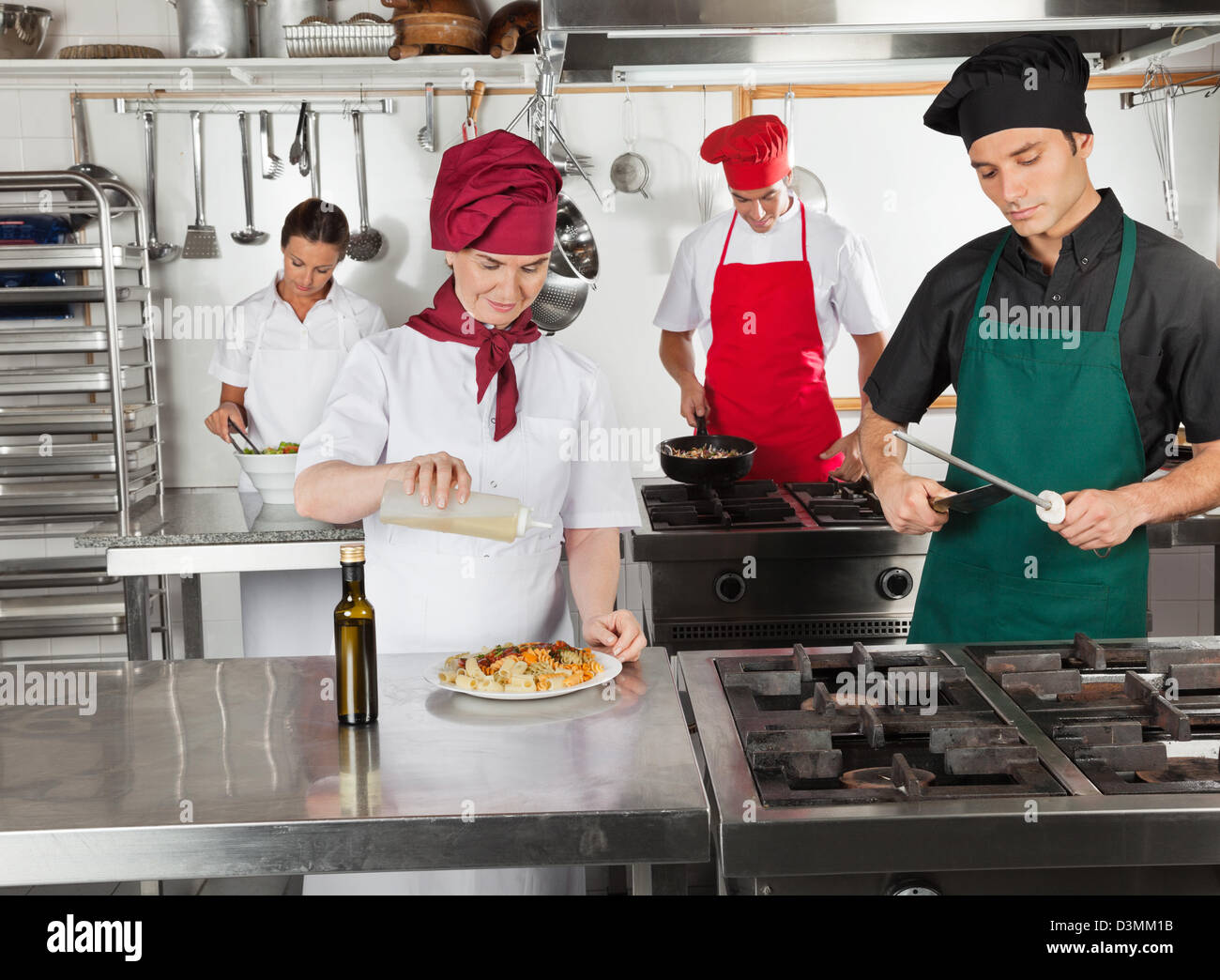 Chefs Working In Restaurant Kitchen Stock Photo - Alamy