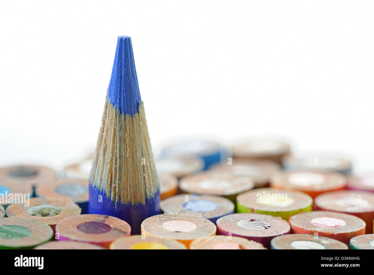 A sharp blue crayon against white background with out of focus crayon ...