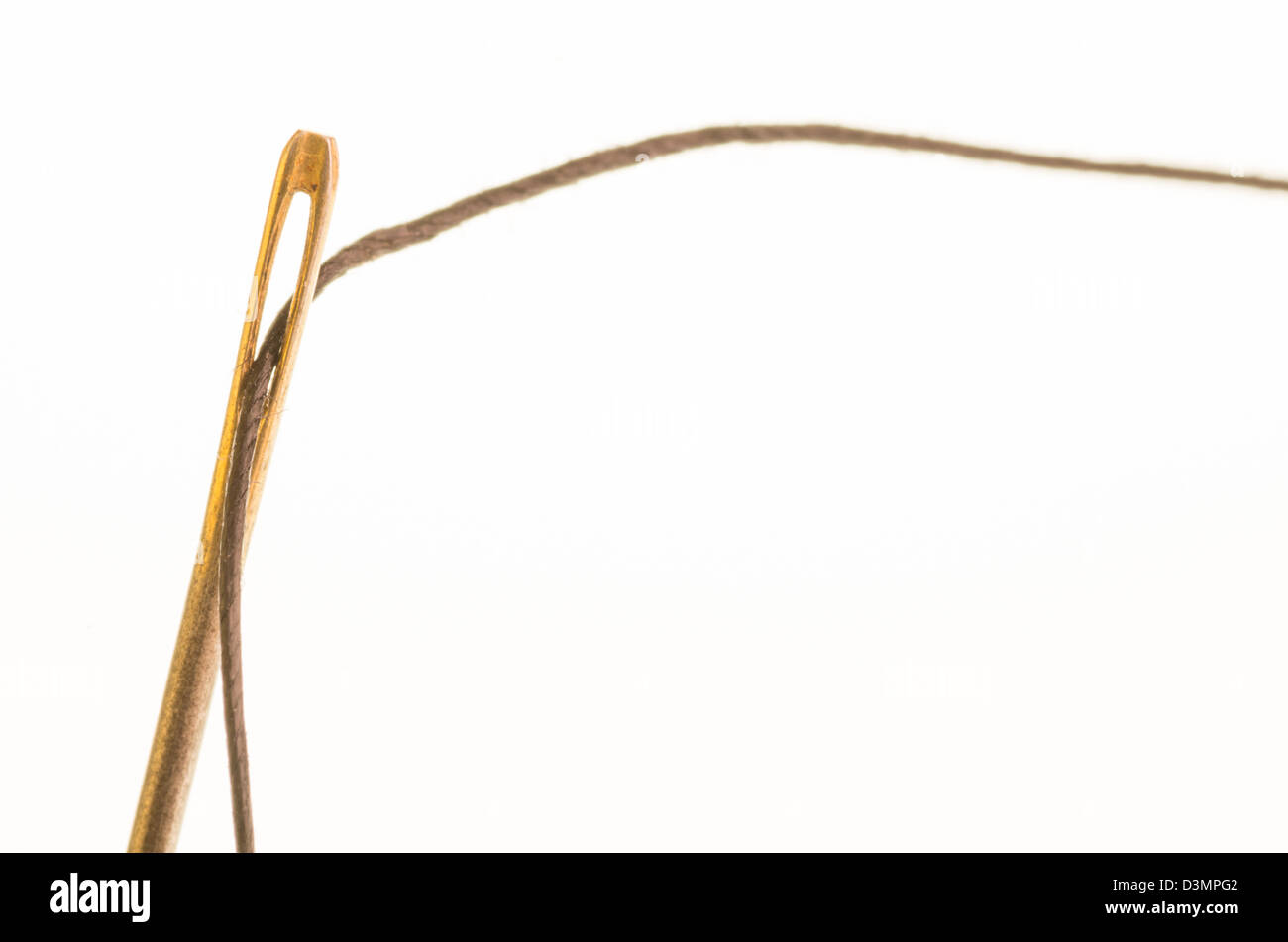 A metal sewing needle with thread through the eye Stock Photo - Alamy