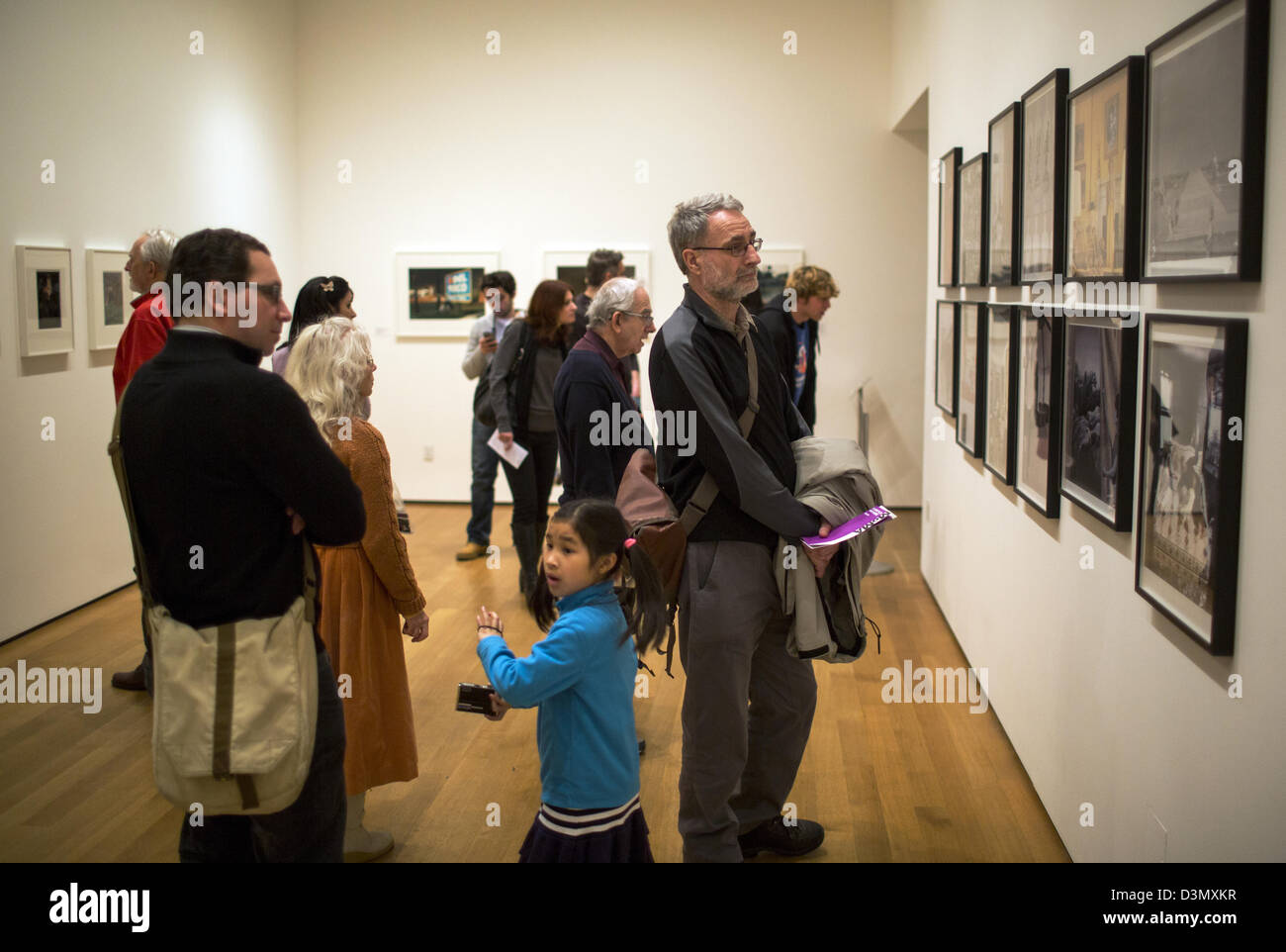 Viewers observe prints at a photography exhibition at the Museum of ...