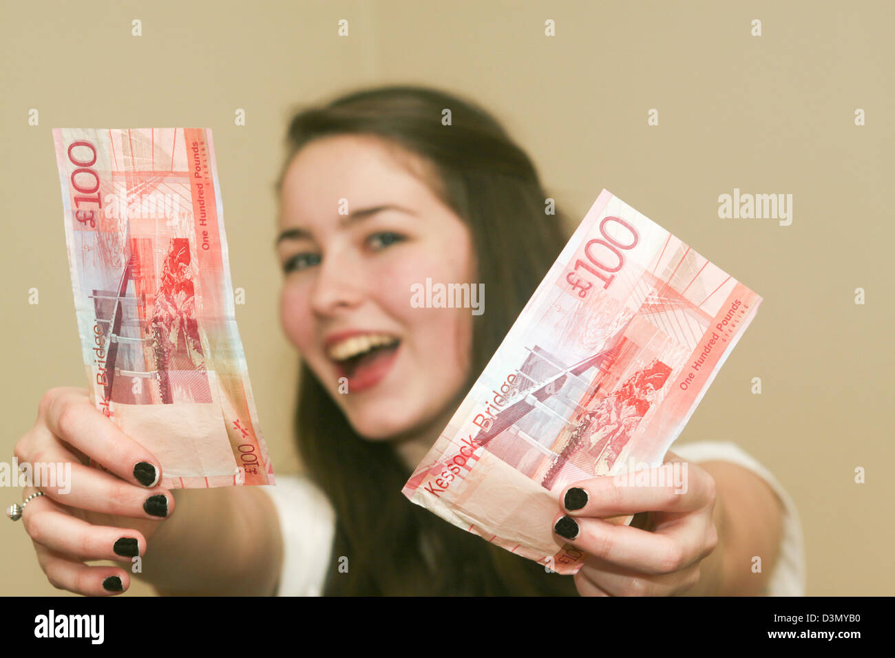 16 year old girl holding two £100 notes Stock Photo - Alamy