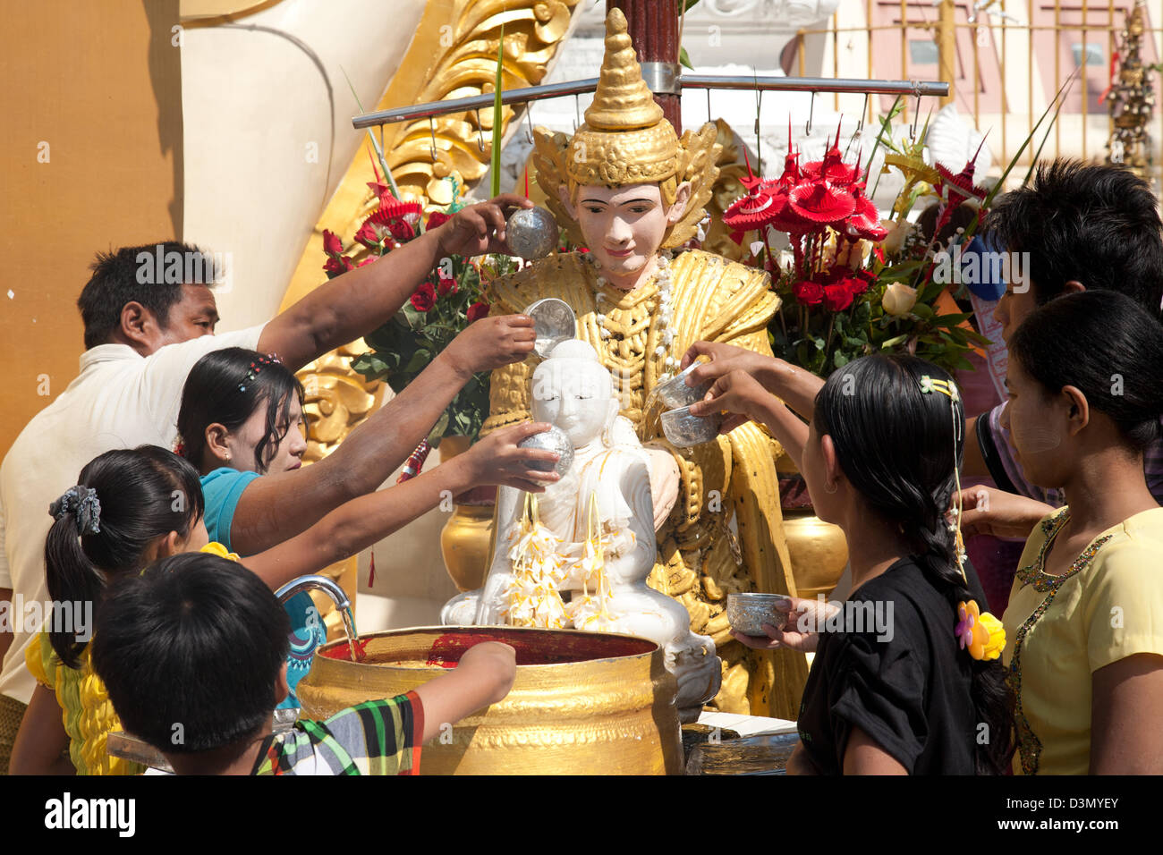 Pouring water over Buddhist statue at the Shwedagon Pagoda in Yangon ...
