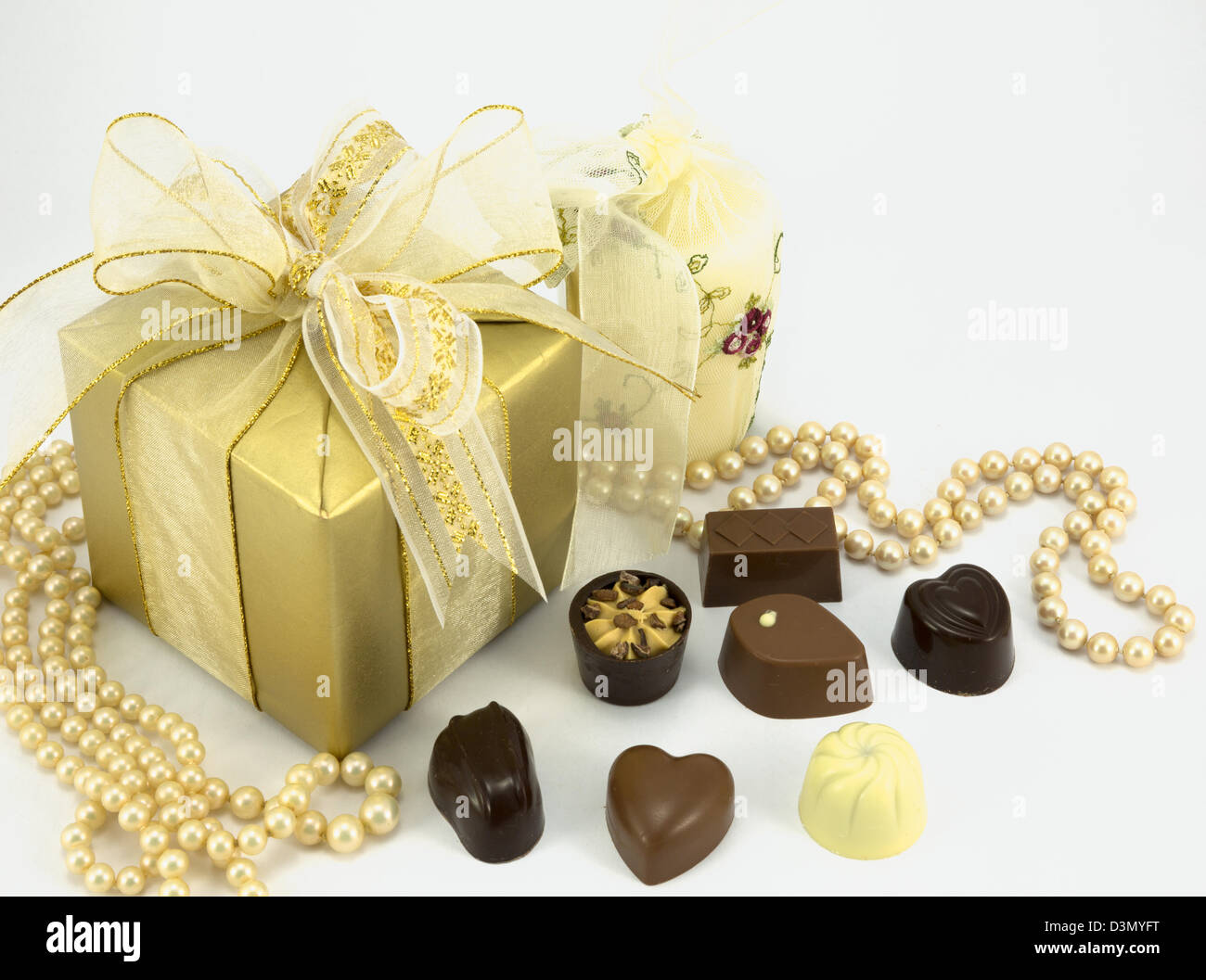 Gold wrapped present with assorted chocolates Stock Photo - Alamy