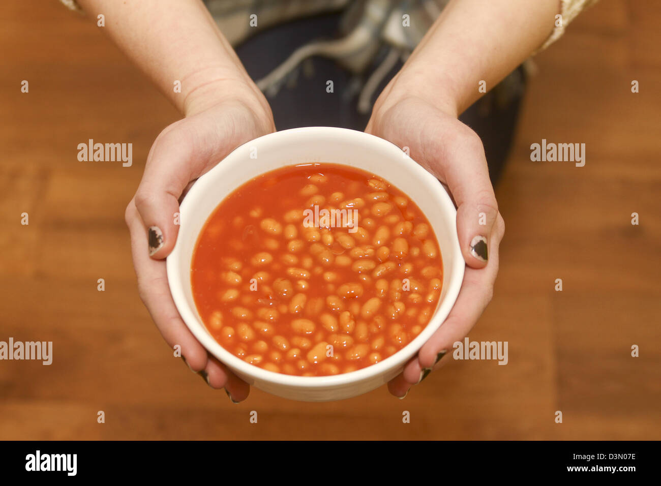 Hands holding bowl of baked beans Stock Photo - Alamy