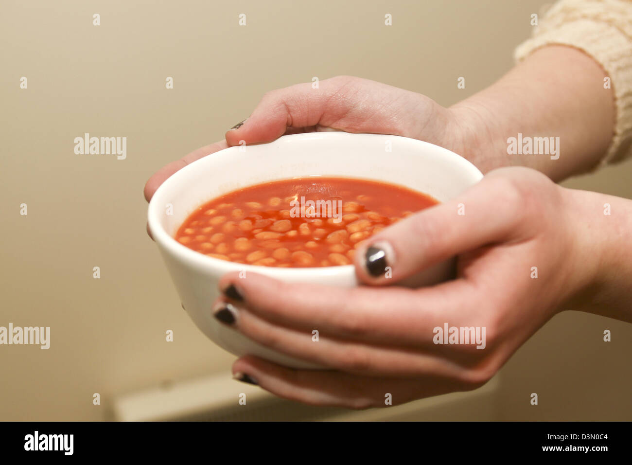 Hands holding bowl of baked beans Stock Photo - Alamy