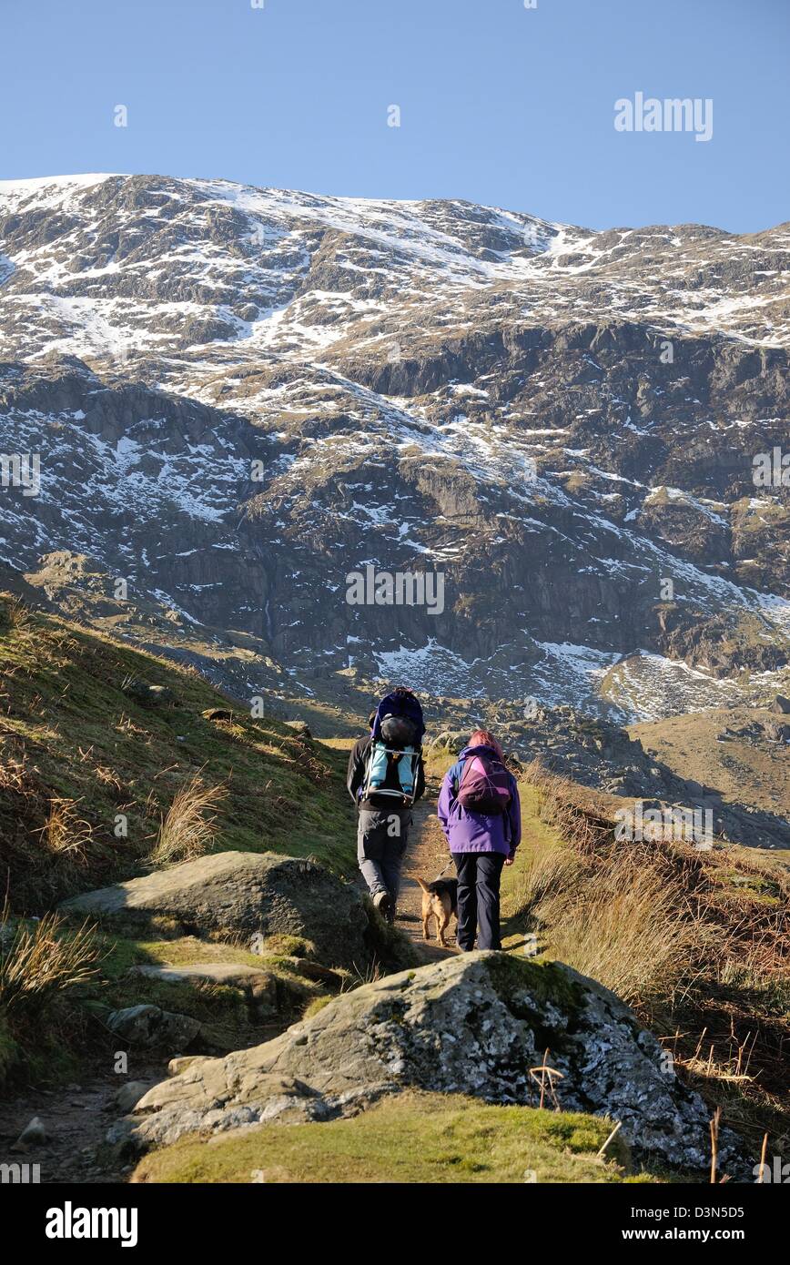 Walkers ascending the Old Man of Coniston in winter in the English lake ...