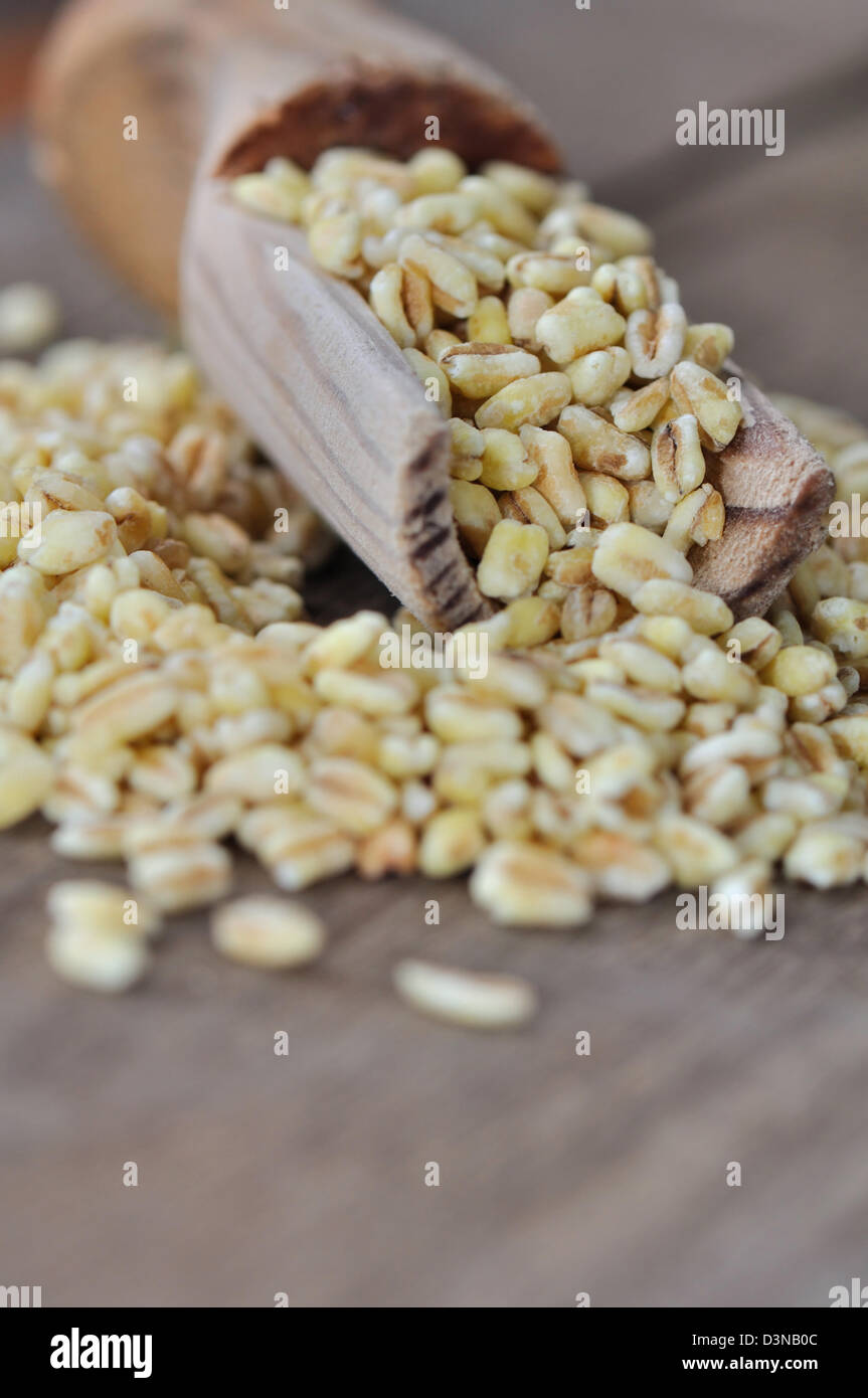 wheat grains in a spoon on wood background Stock Photo - Alamy