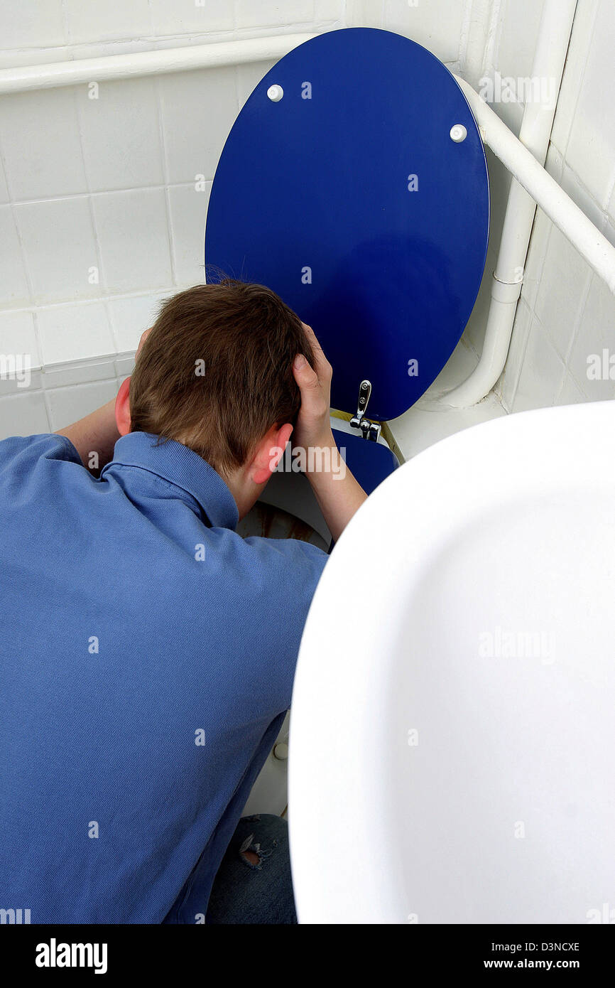 A teenager boy vomits into a flush lavatory in Frankfurt Main, Germany ...