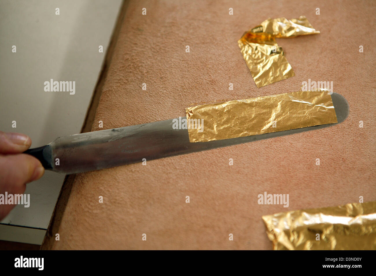 Beaten gold is cut with a knife, Germany, 2005. Photo: Heinz von ...