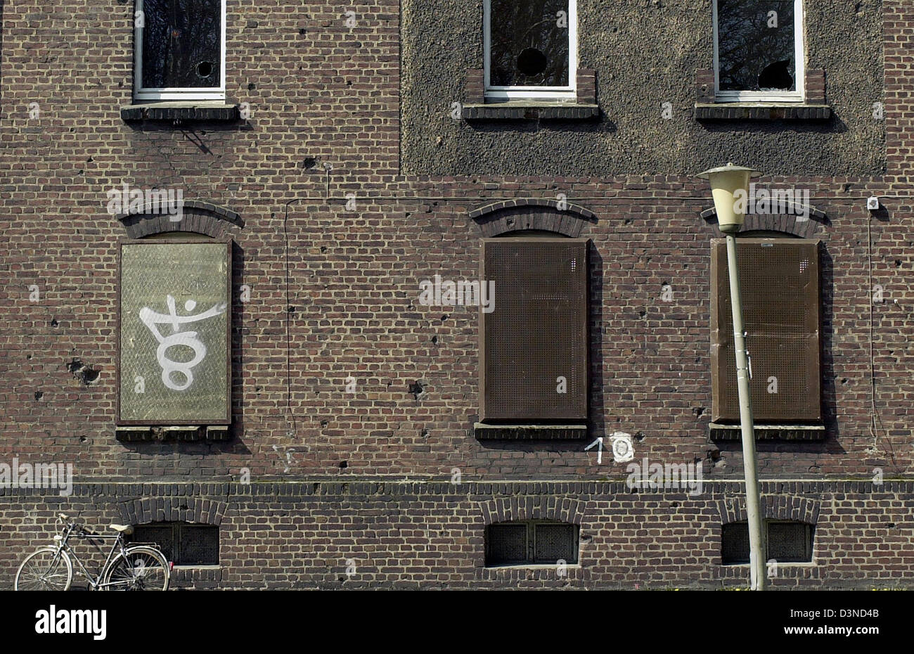 A view of the scruffy brick facade of a run-down residential house in ...