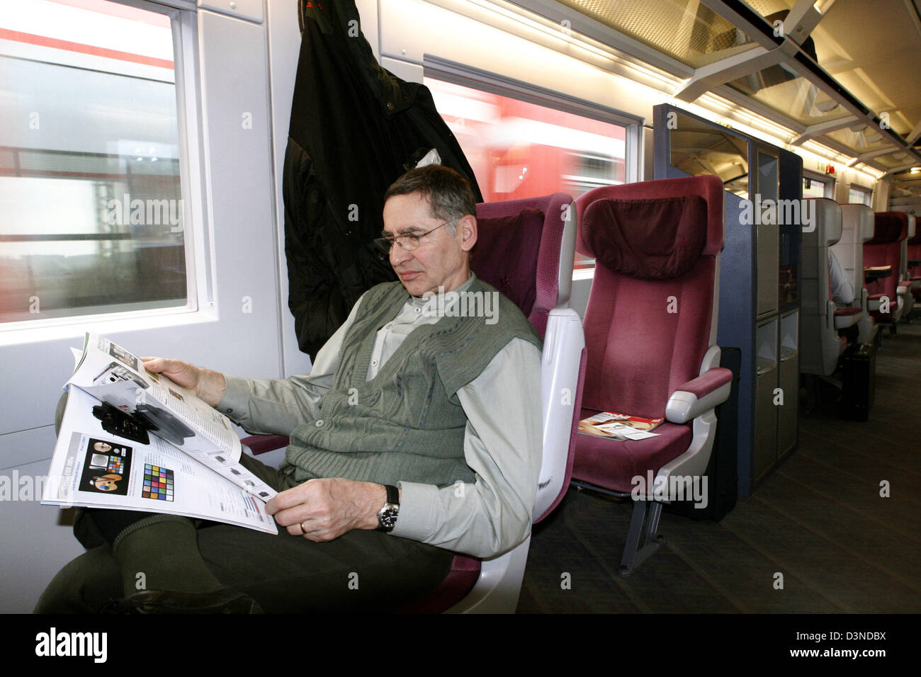 A passenger reads in a magazine in the first class coach of an ...