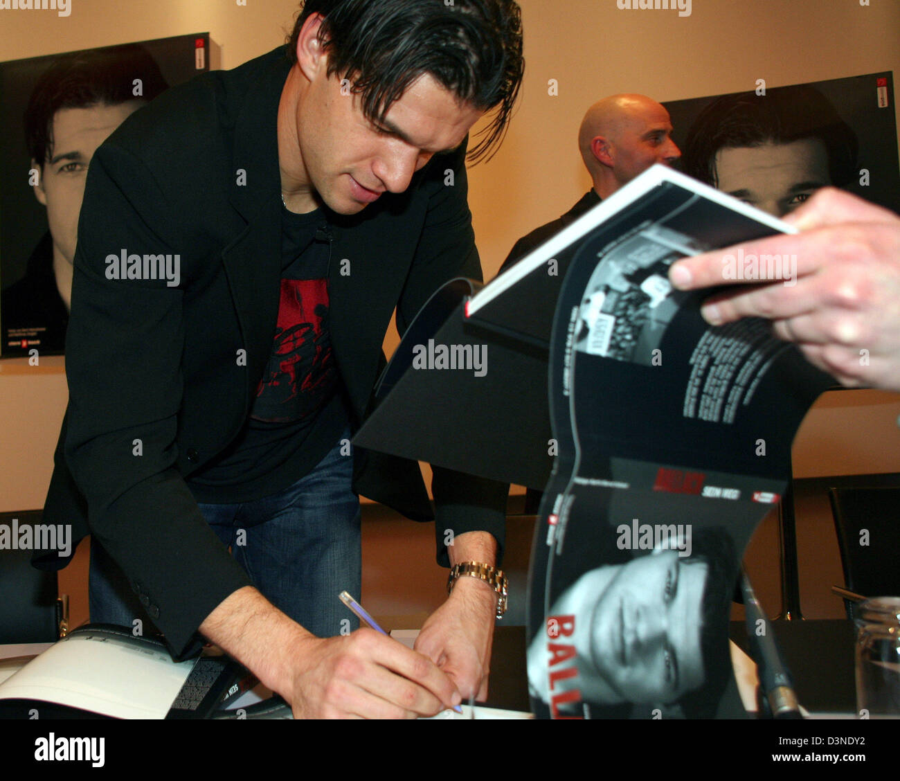The German national soccer player Michael Ballack autographs copies ...