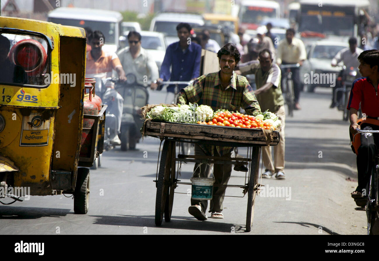 A vegetable dealer pushes a mobile stand through a heavily frequented ...