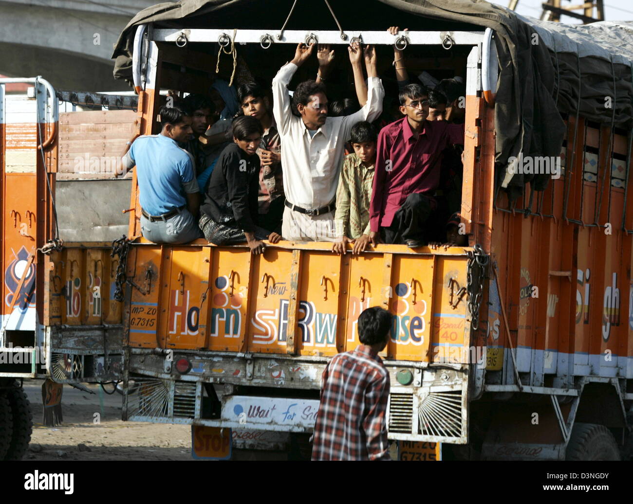 Indian men are transported on the back of a lorry in Indore, India, 28 ...