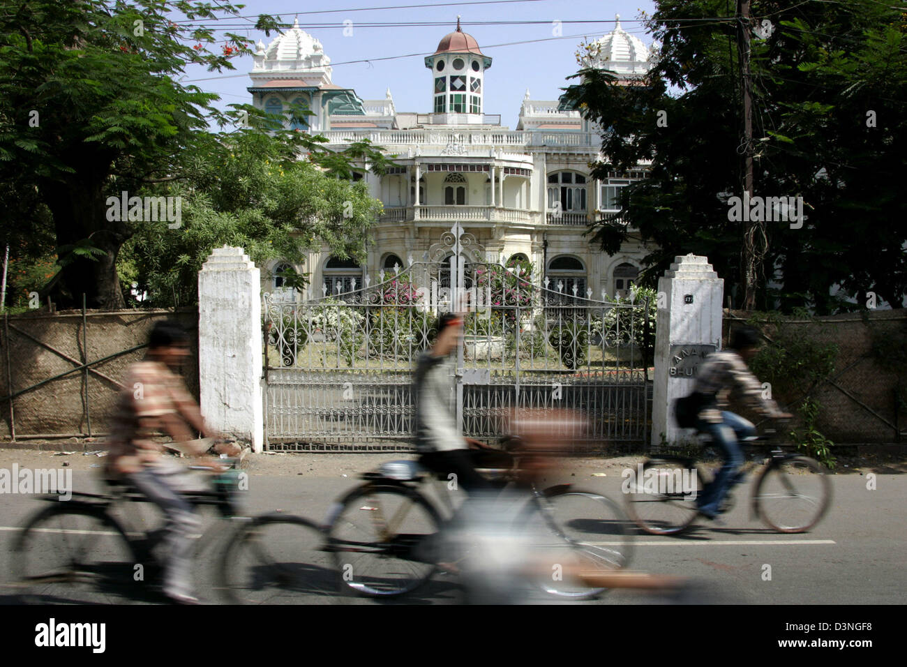 Cyclists pass a luxurious colonial-style mansion in Indore, India, 28 ...