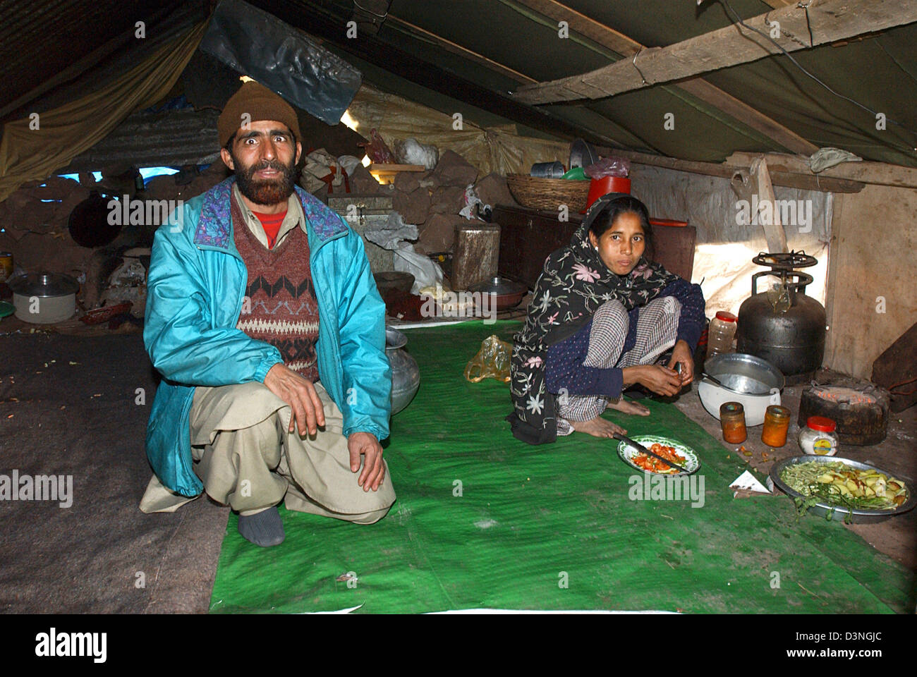 A Pakistani man and his wife sit in a refugee camp near Muzaffarabad in ...