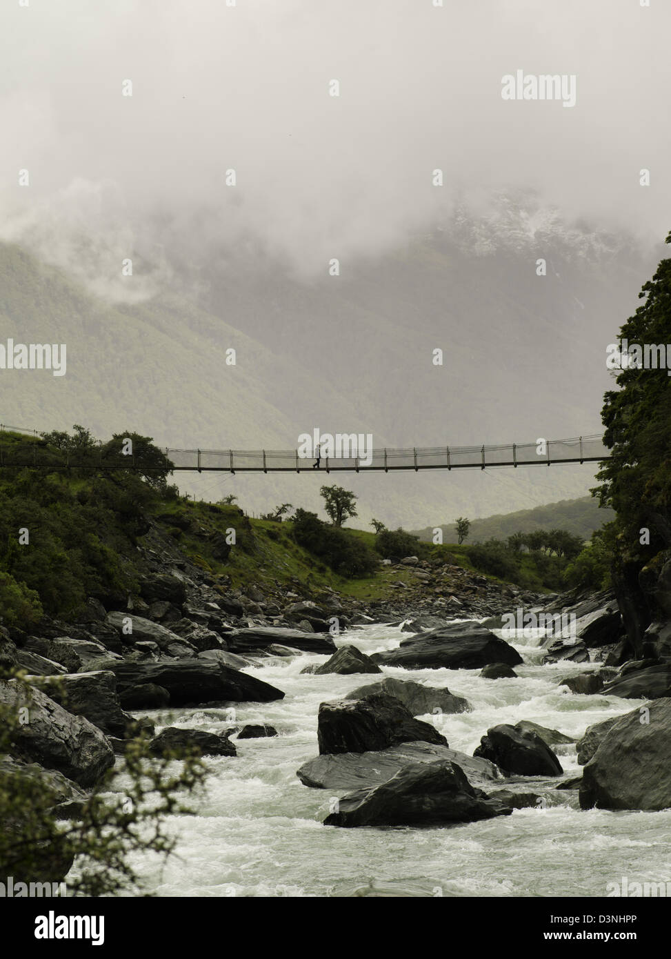 A boy crosses a suspension bridge over the Matukituki River; the Rob ...