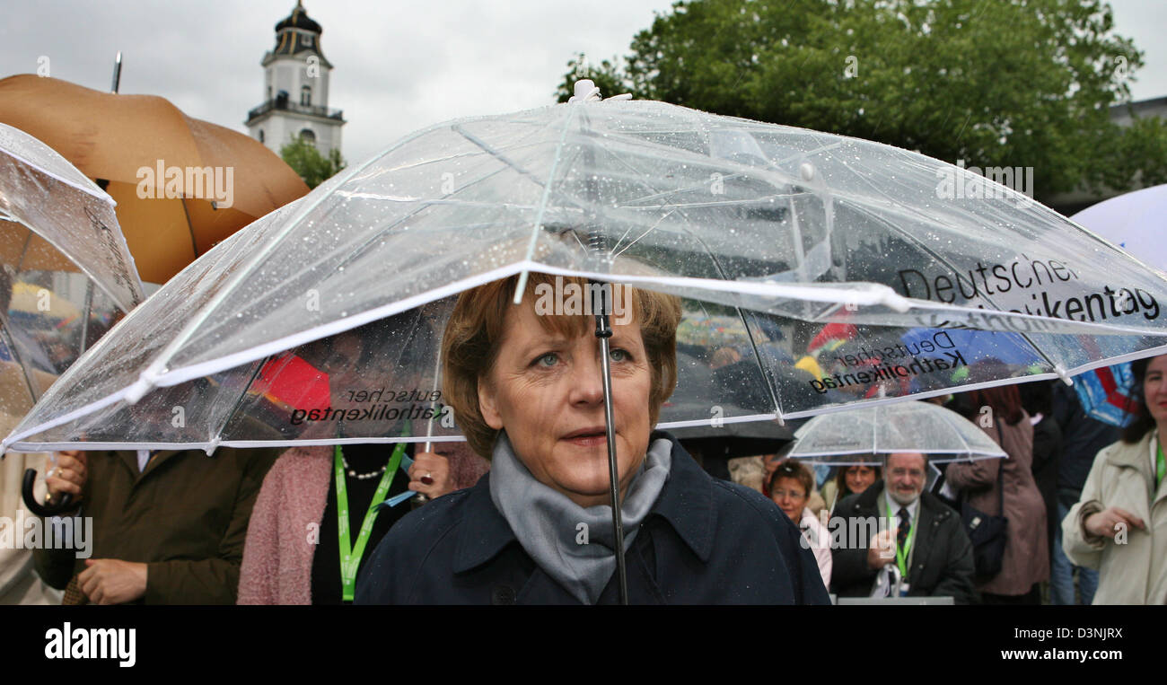 German Chancellor Angela Merkel arrives with a transparent umbrella for ...