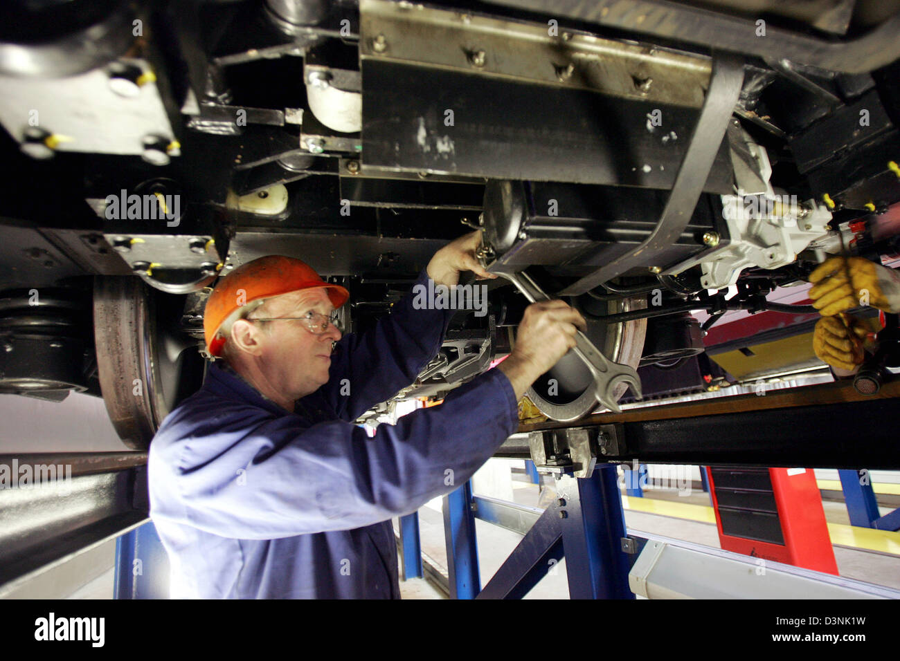 An employee of the Deutsche Bahn screws on a pivot bogie of a diesel ...