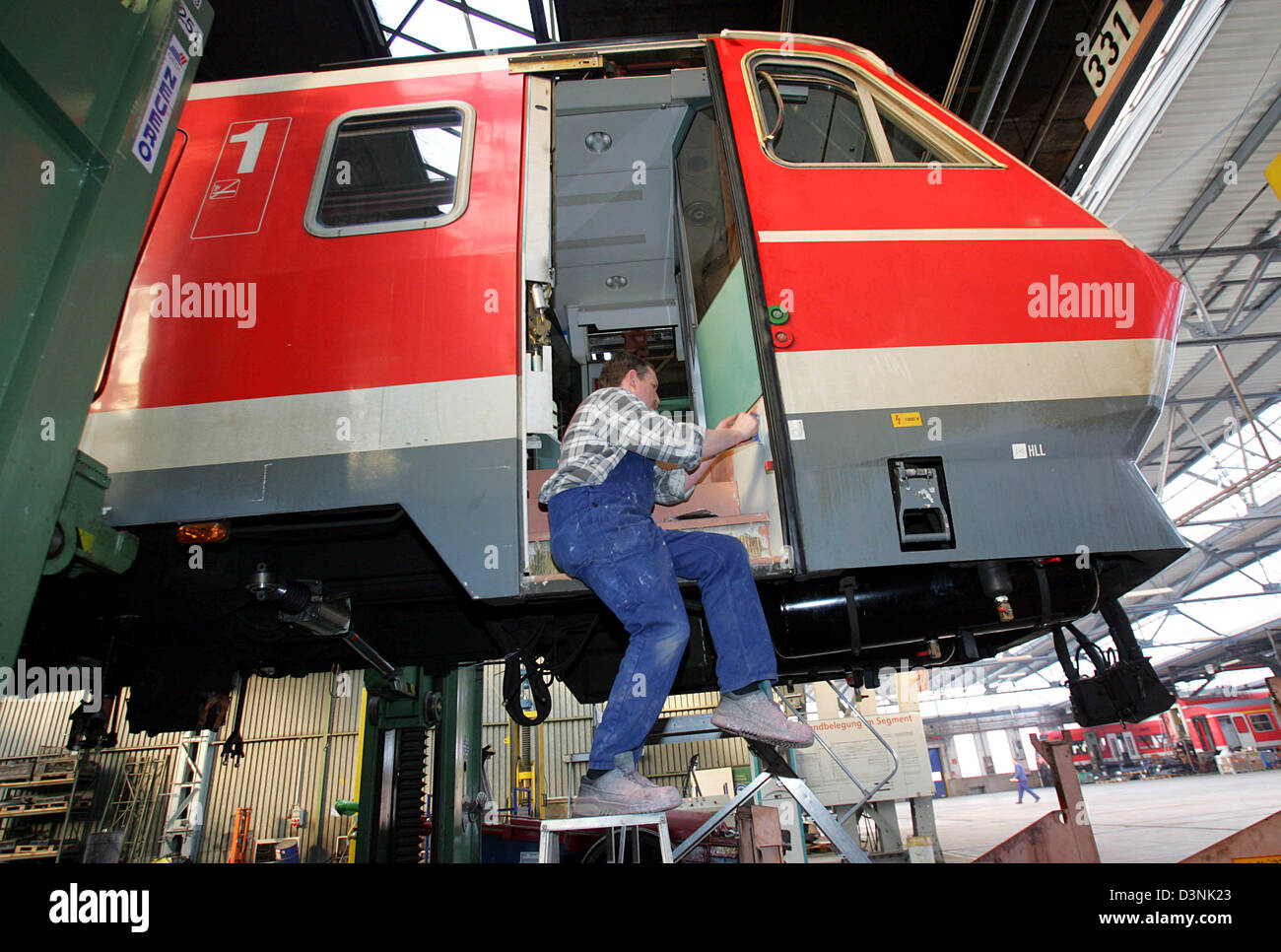 A staff member of the Deutsche Bahn works on a diesel multiple unit in ...